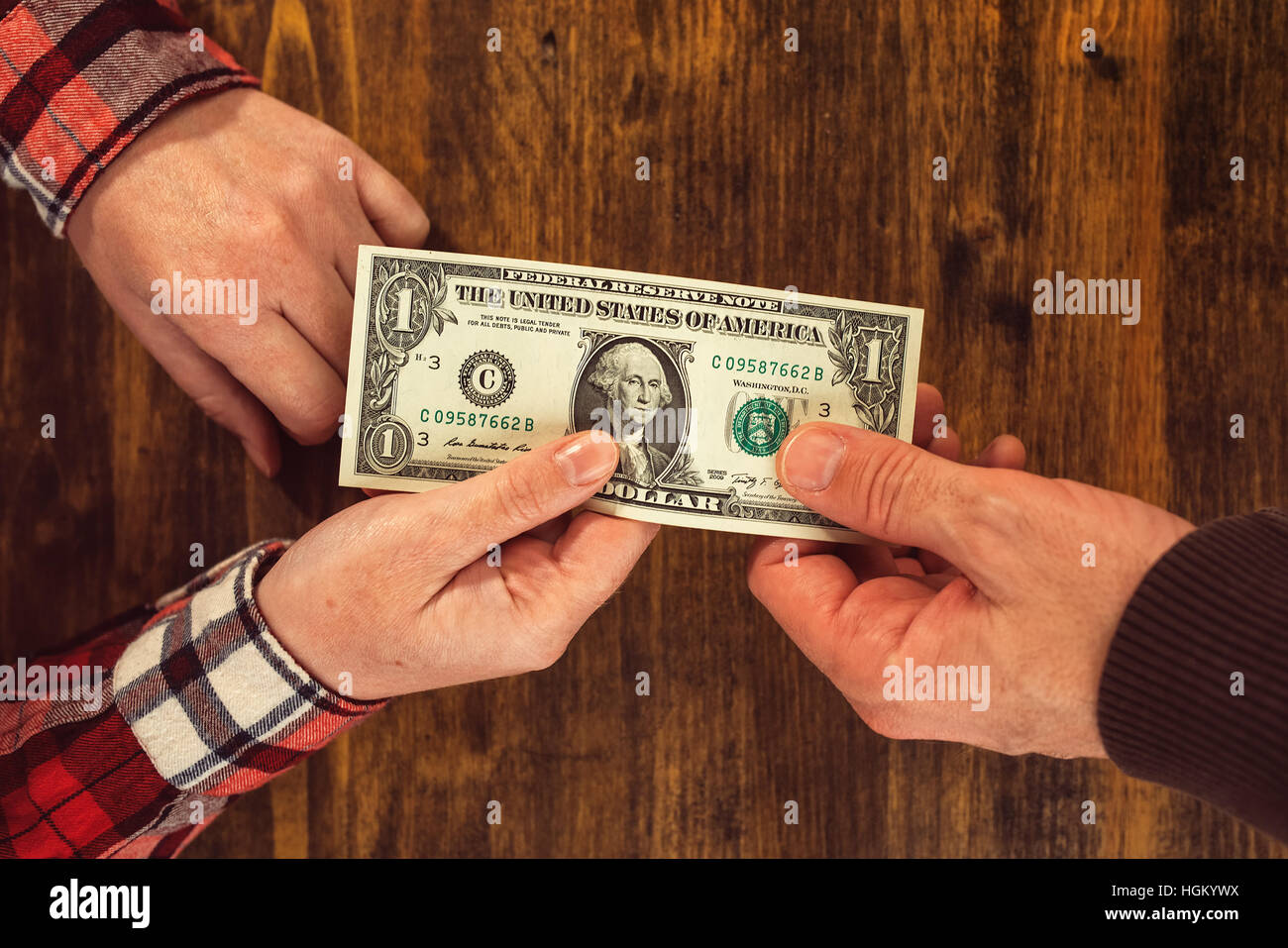Woman offering one dollar bill to a man, top view of business office ...