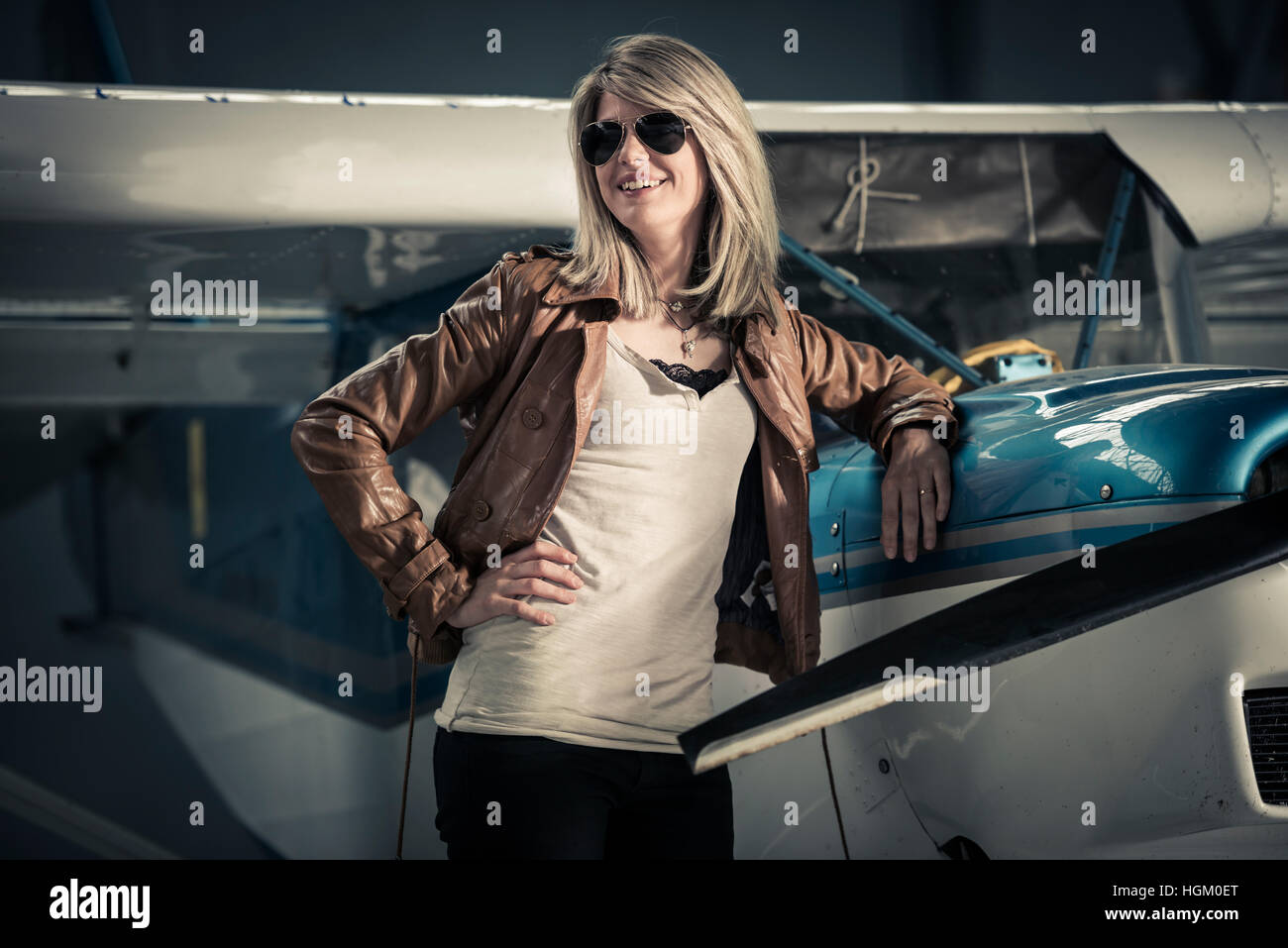 A woman pilot standing next to airplane Stock Photo - Alamy