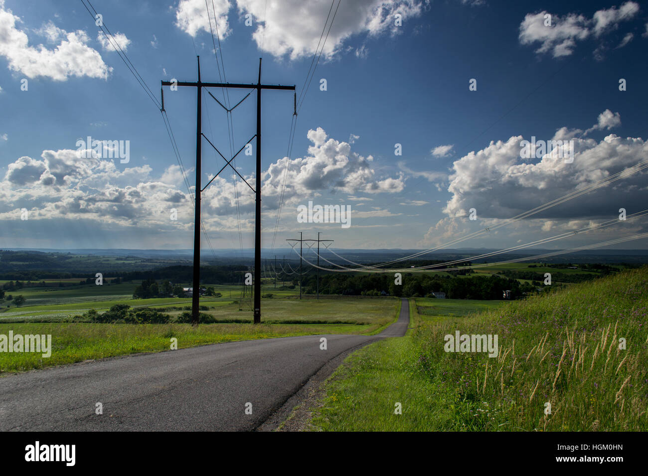 Powerlines in front of a road going into the distance Stock Photo - Alamy