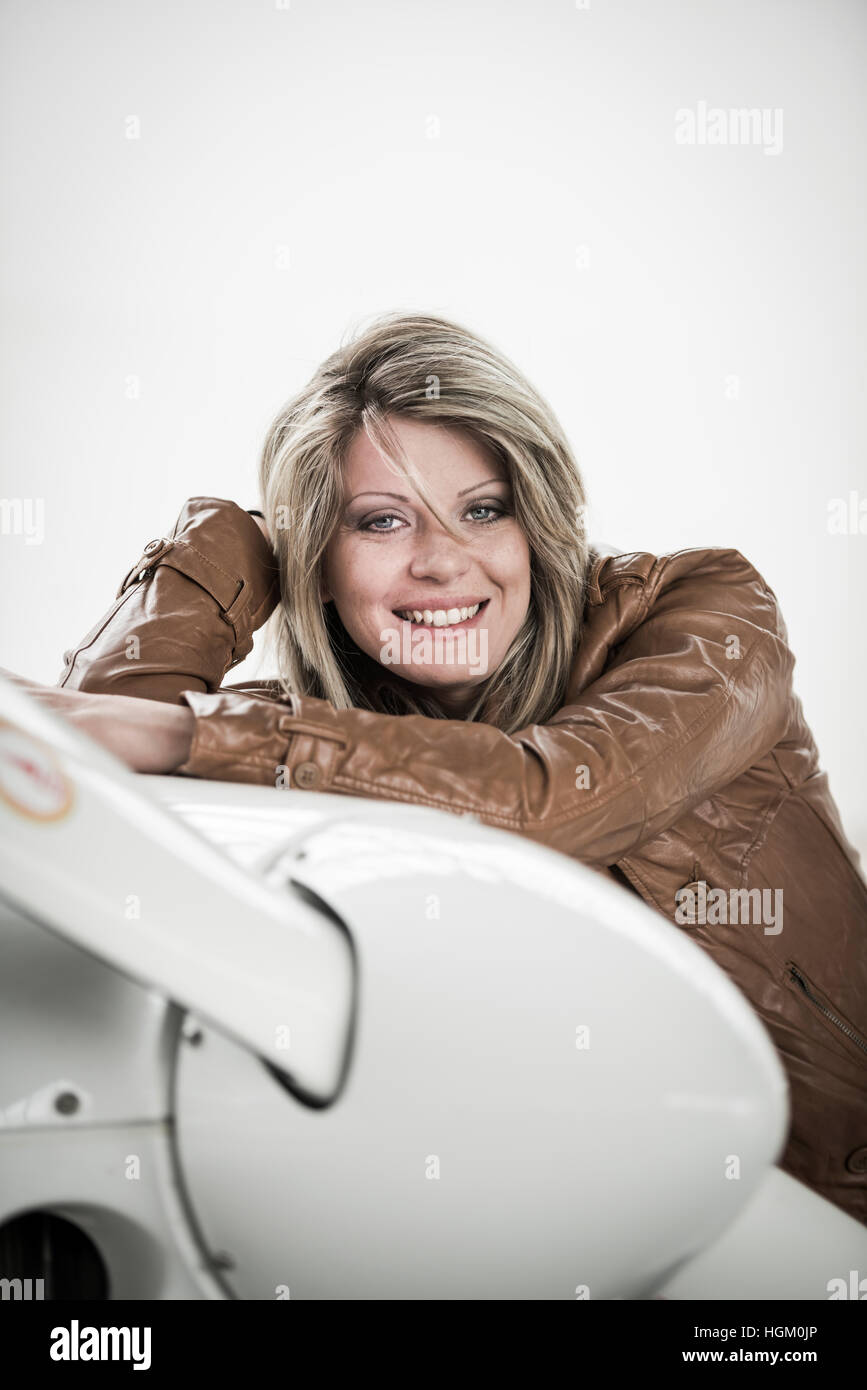 A woman pilot standing next to airplane, looking at camera Stock Photo ...