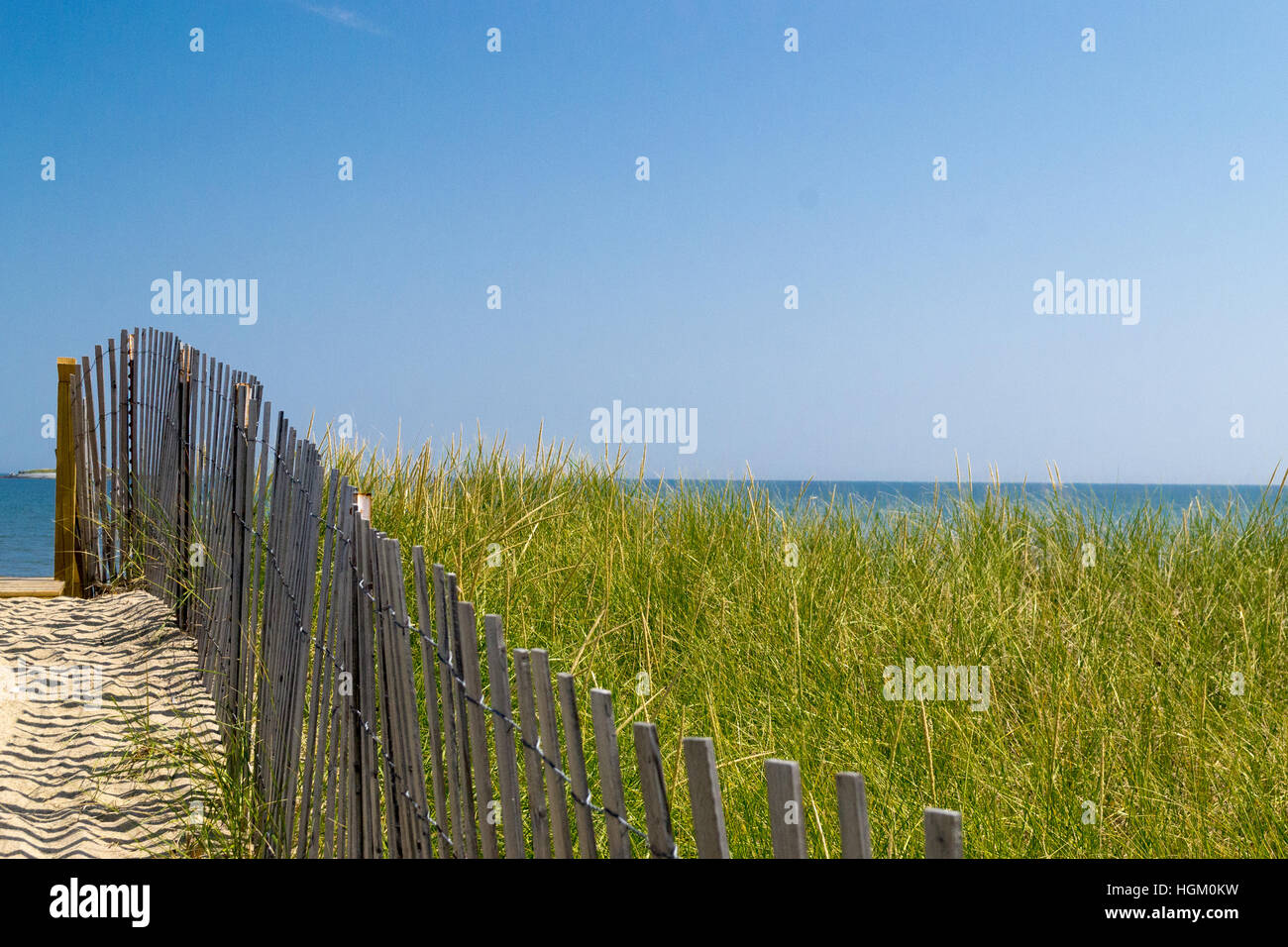 sandy beach with fence and grass Stock Photo - Alamy