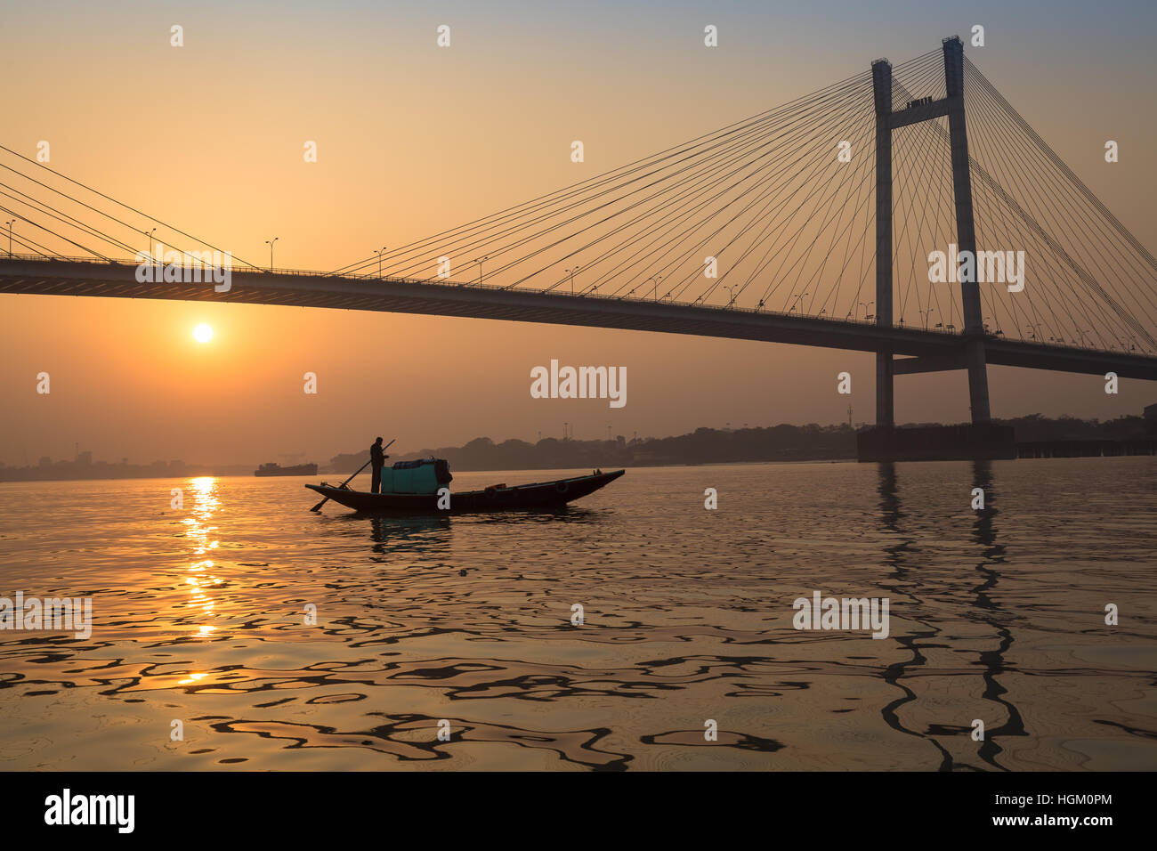 Wooden boat on river Hooghly at sunset with Vidyasagar Setu bridge at ...