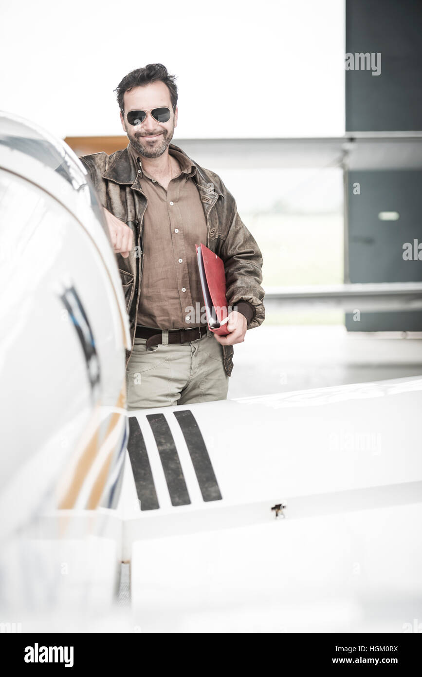 Happy pilot standing next to his airplane Stock Photo - Alamy