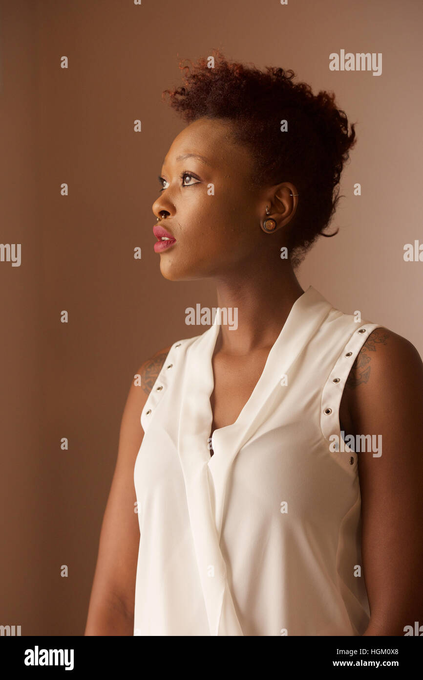 Young beautiful African woman in a white top, indoors Stock Photo - Alamy