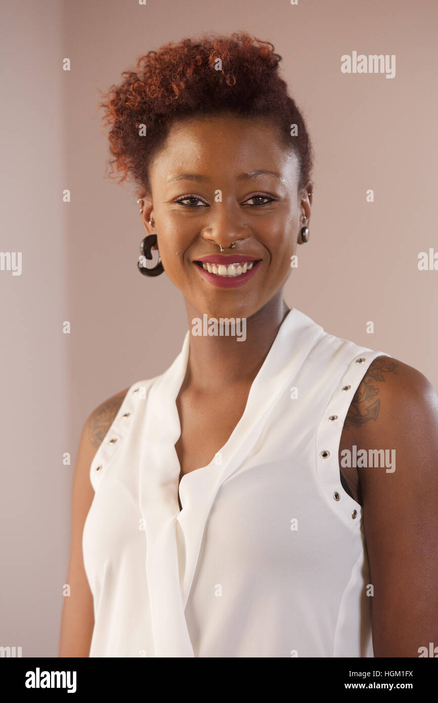 Young beautiful African woman in a white top, indoors Stock Photo - Alamy