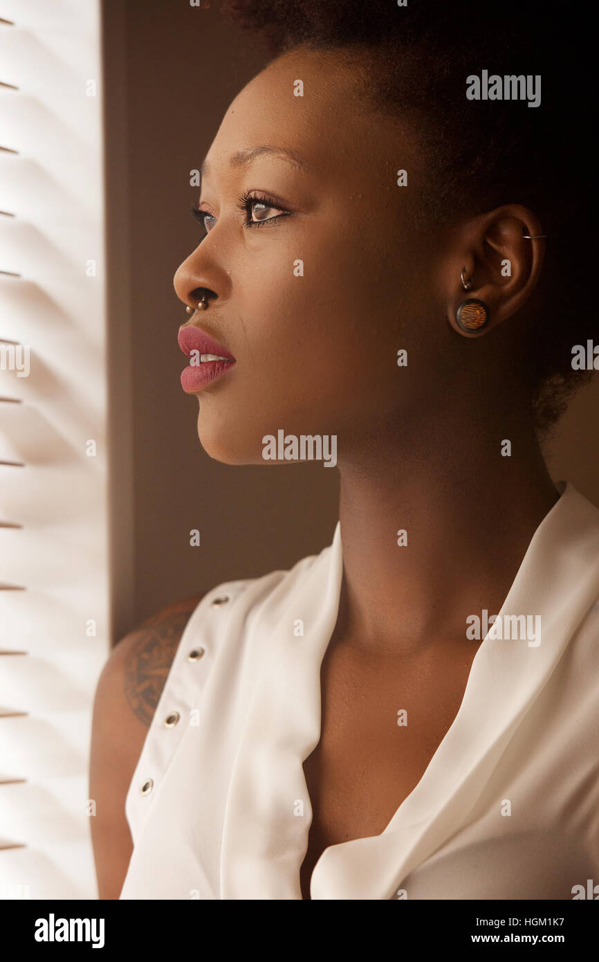 Young beautiful African woman in a white top, indoors Stock Photo - Alamy