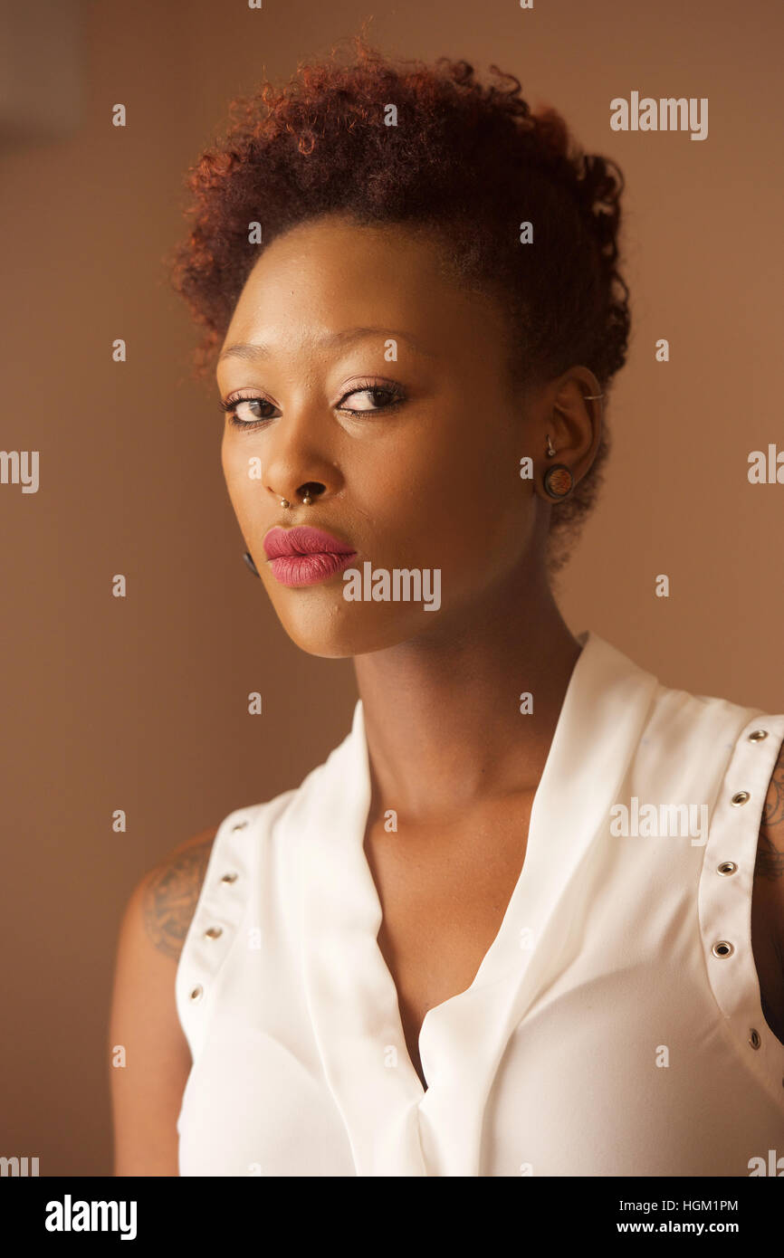 Young beautiful African woman in a white top, indoors Stock Photo - Alamy