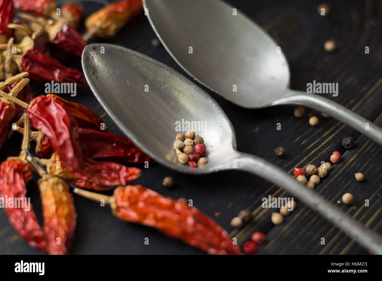Two old tin spoons with red hot chili cayenne peppers dried, variety ...