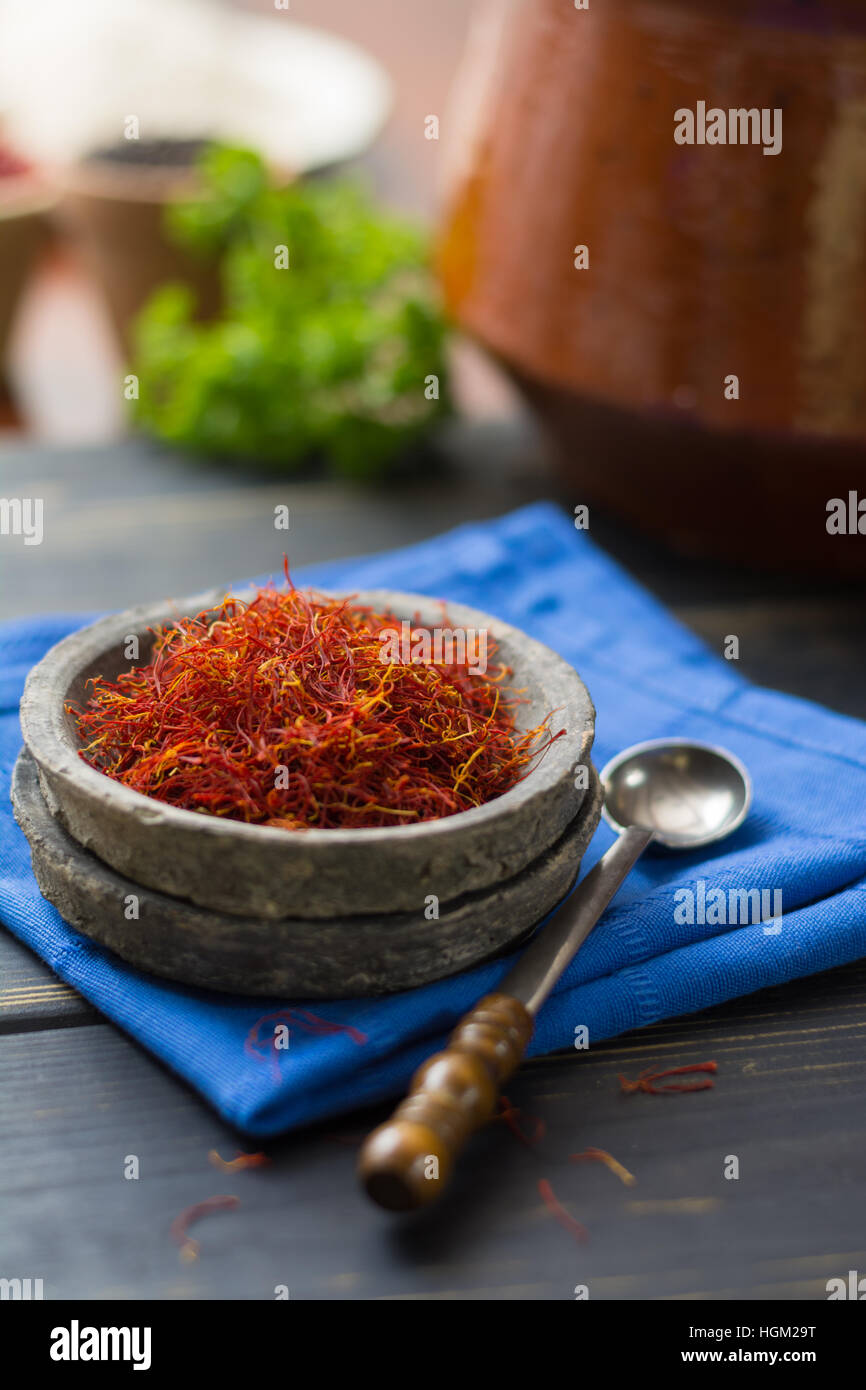 Raw Organic Red Saffron Spice in a clay bowl on wooden table Stock ...