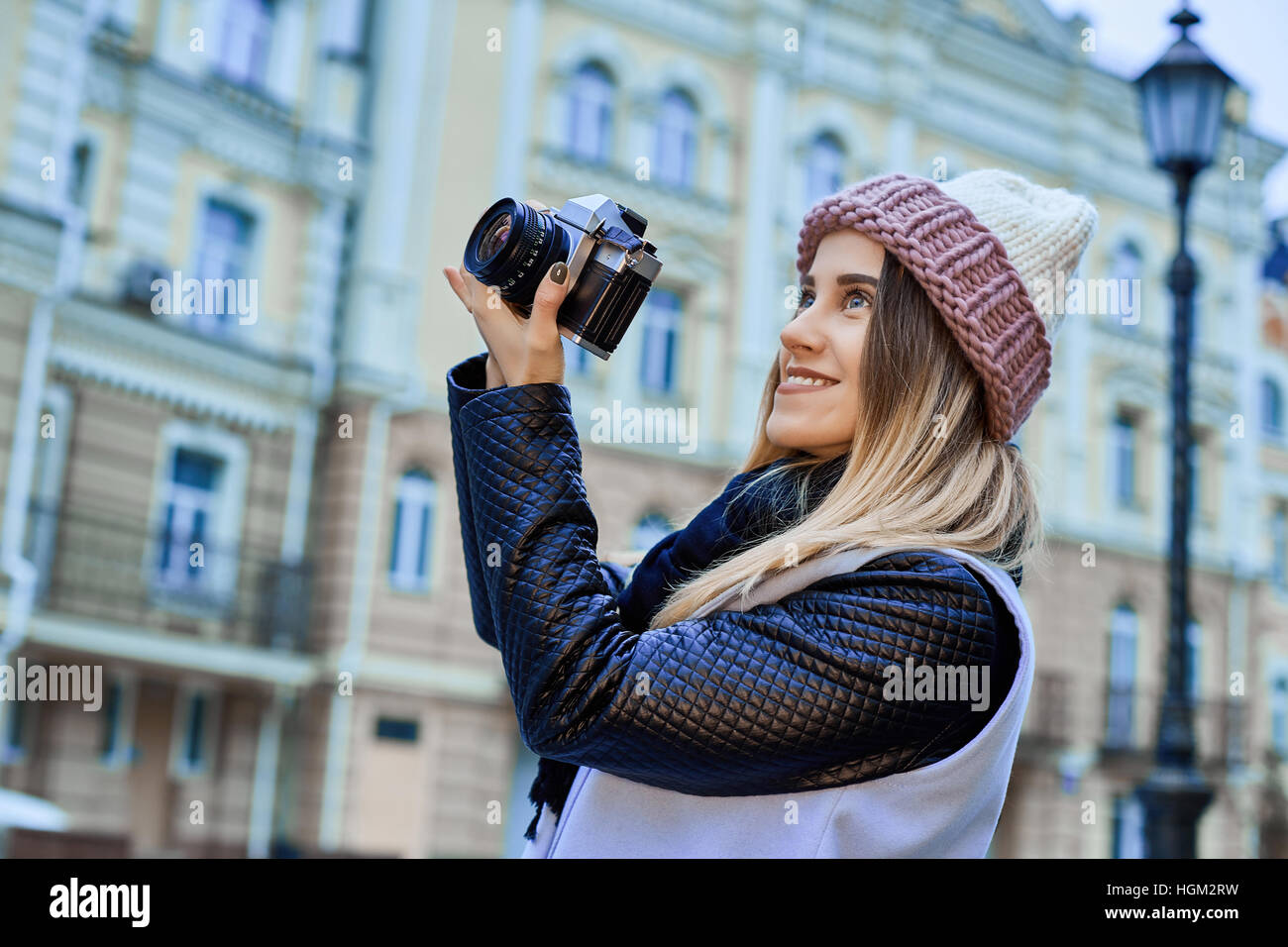 Beautiful girl photographer photographing the old town with retro ...