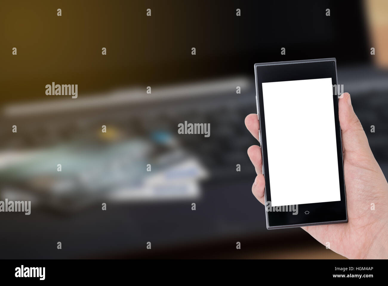 Hands holding smartphone with credit card on laptop blur background ...