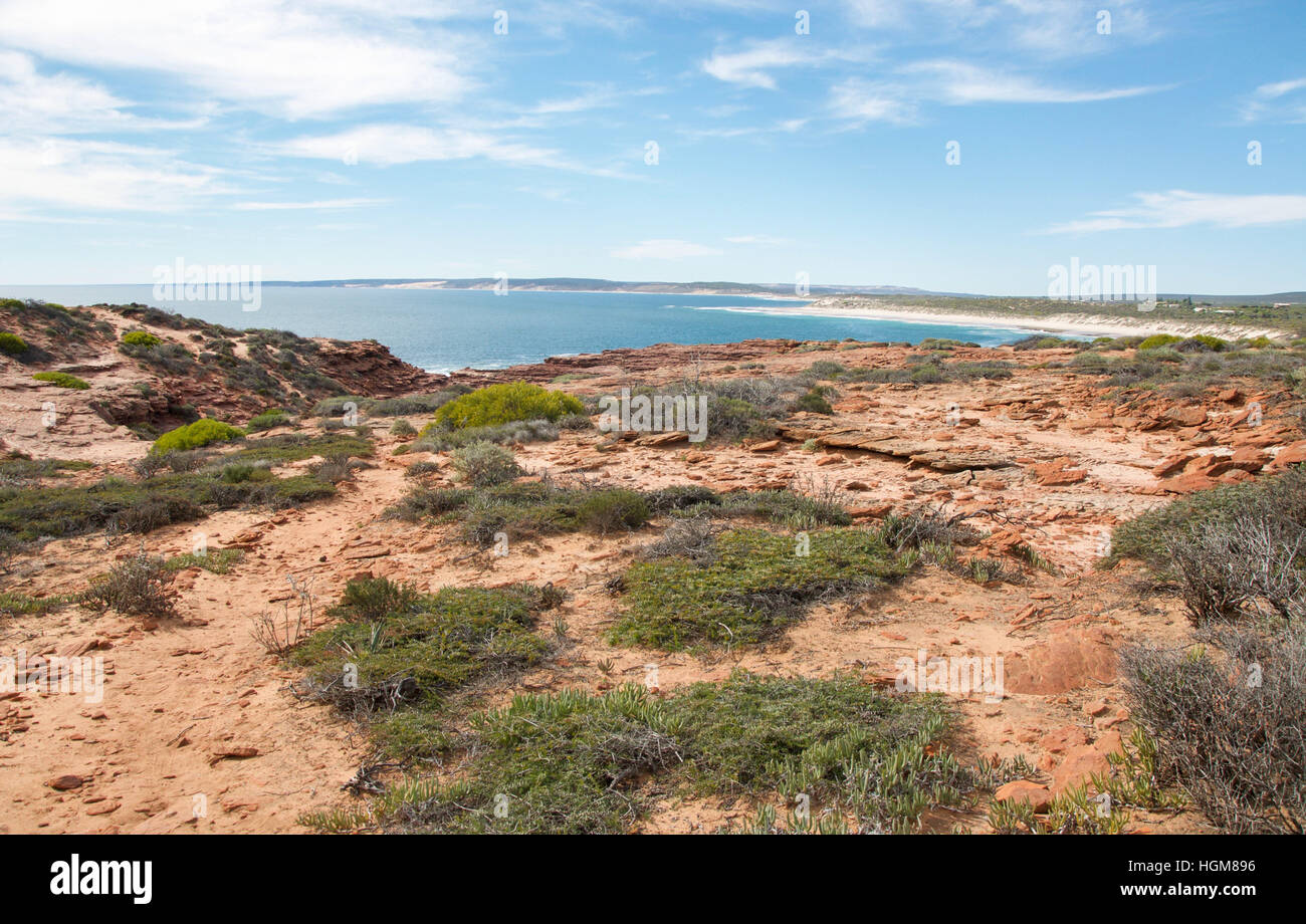 Red bluff beach with Indian Ocean seascape and rugged sandstone terrain ...