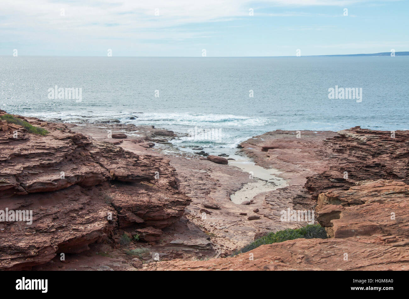Eroded sandstone rock bluff and inlet with the Indian Ocean waters on ...
