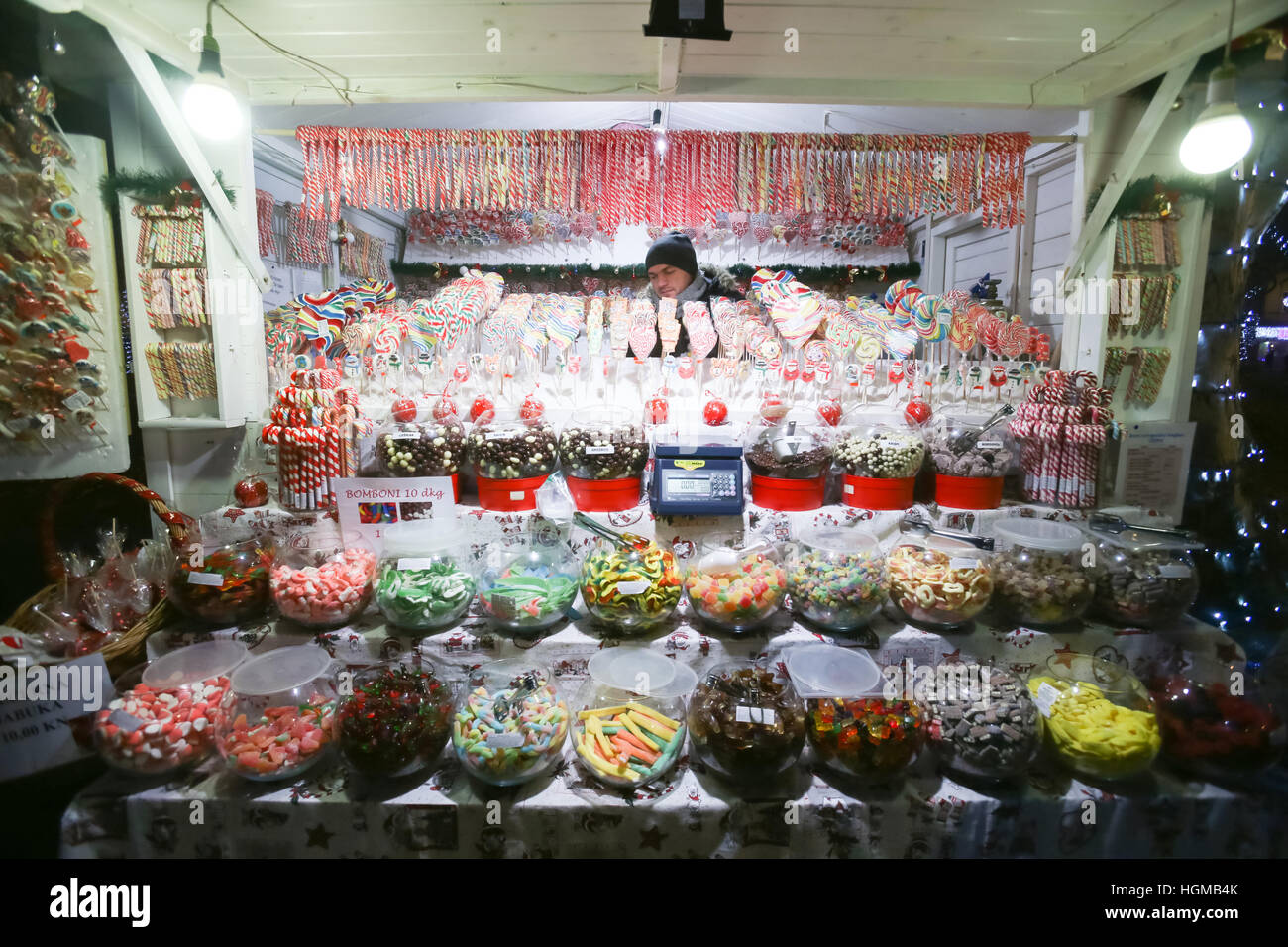 A man selling sweets at a street stand full of candy at Advent time in ...