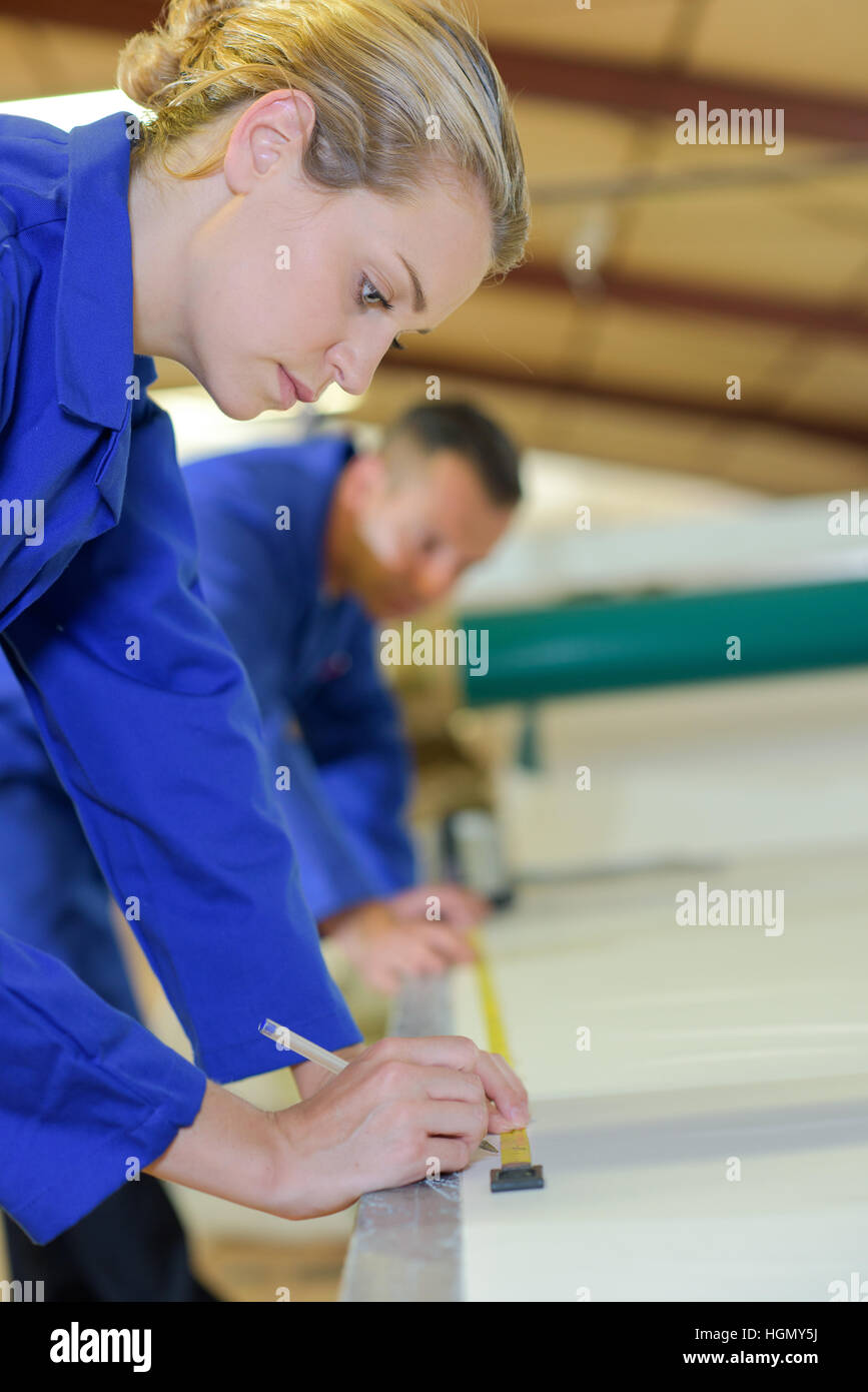 Female worker measuring and marking material Stock Photo - Alamy