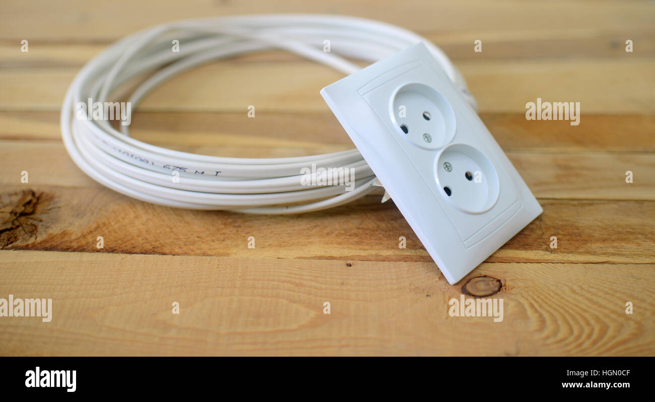 coil of electrical cable and outlet on wooden background Stock Photo ...
