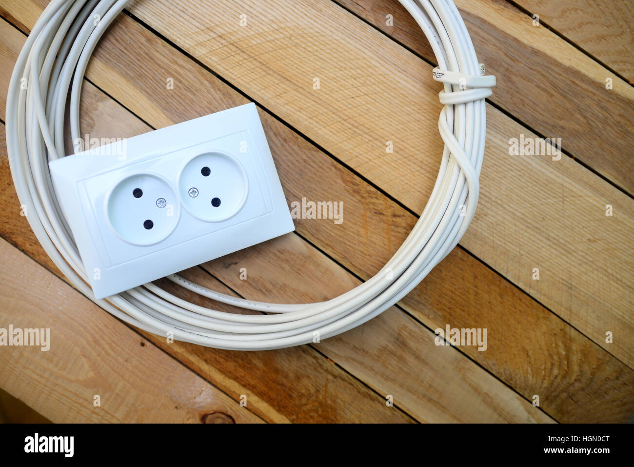 coil of electrical cable and outlet on wooden background Stock Photo ...