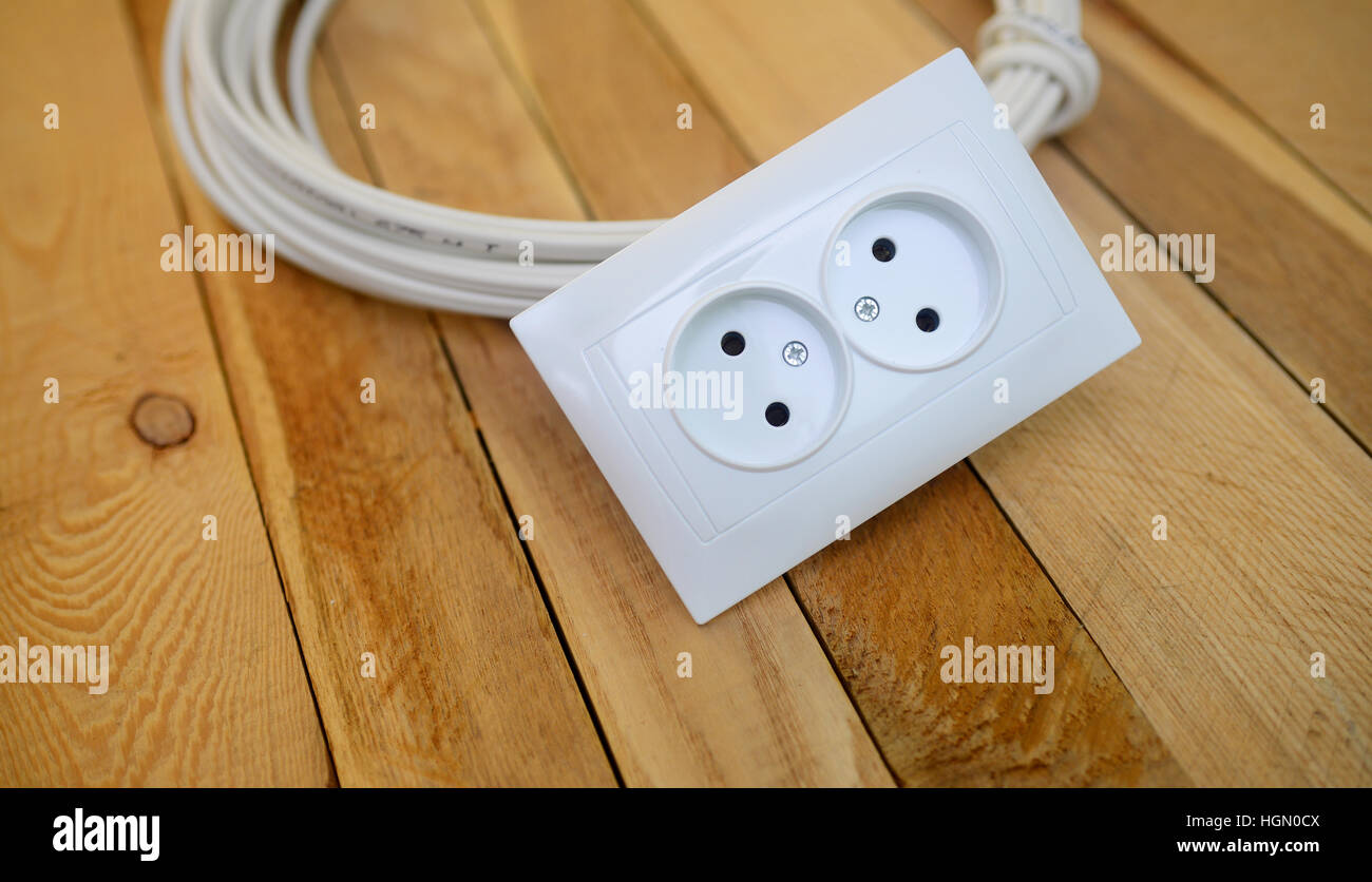 coil of electrical cable and outlet on wooden background Stock Photo ...