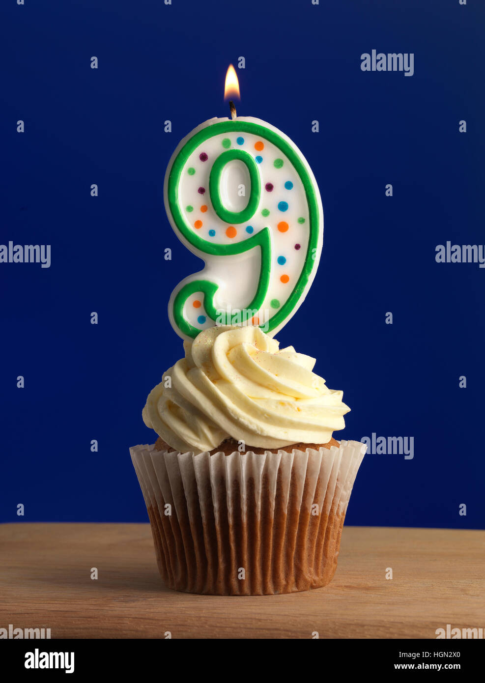 Cupcake with frosting and candle with number nine and a Blue Background ...