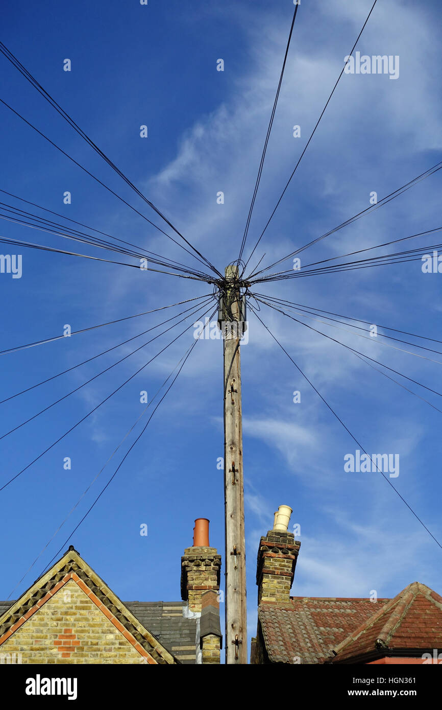 Telephone lines attached to telegraph pole above houses in London Stock ...