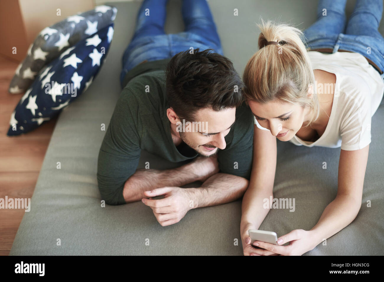 Couple using cell phone in their new home Stock Photo - Alamy