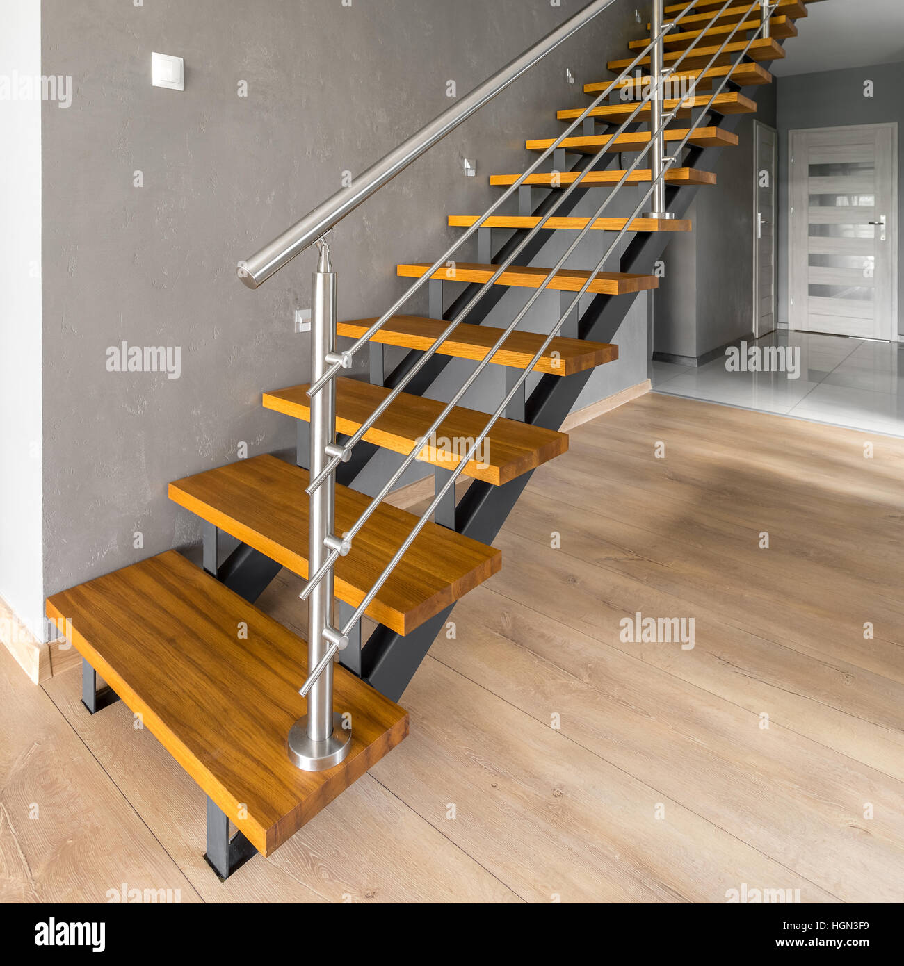 Wooden stairs with silver railing in modern home interior Stock Photo ...