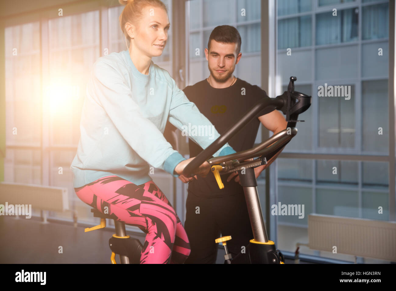 Trainer instructs woman on simulator Stock Photo - Alamy