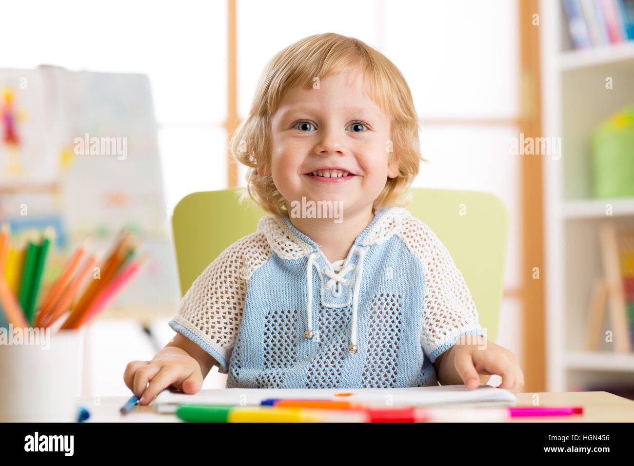 cute child little boy drawing with felt-tip pen in kindergarten ...