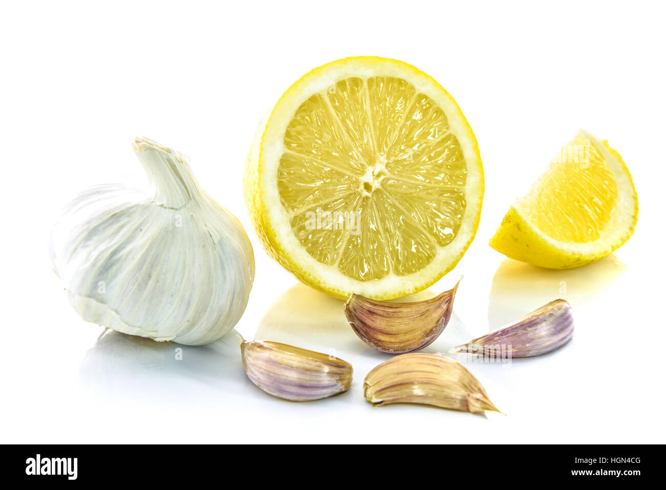 Garlic bulb and clove with sliced lemon isolated on a white background ...
