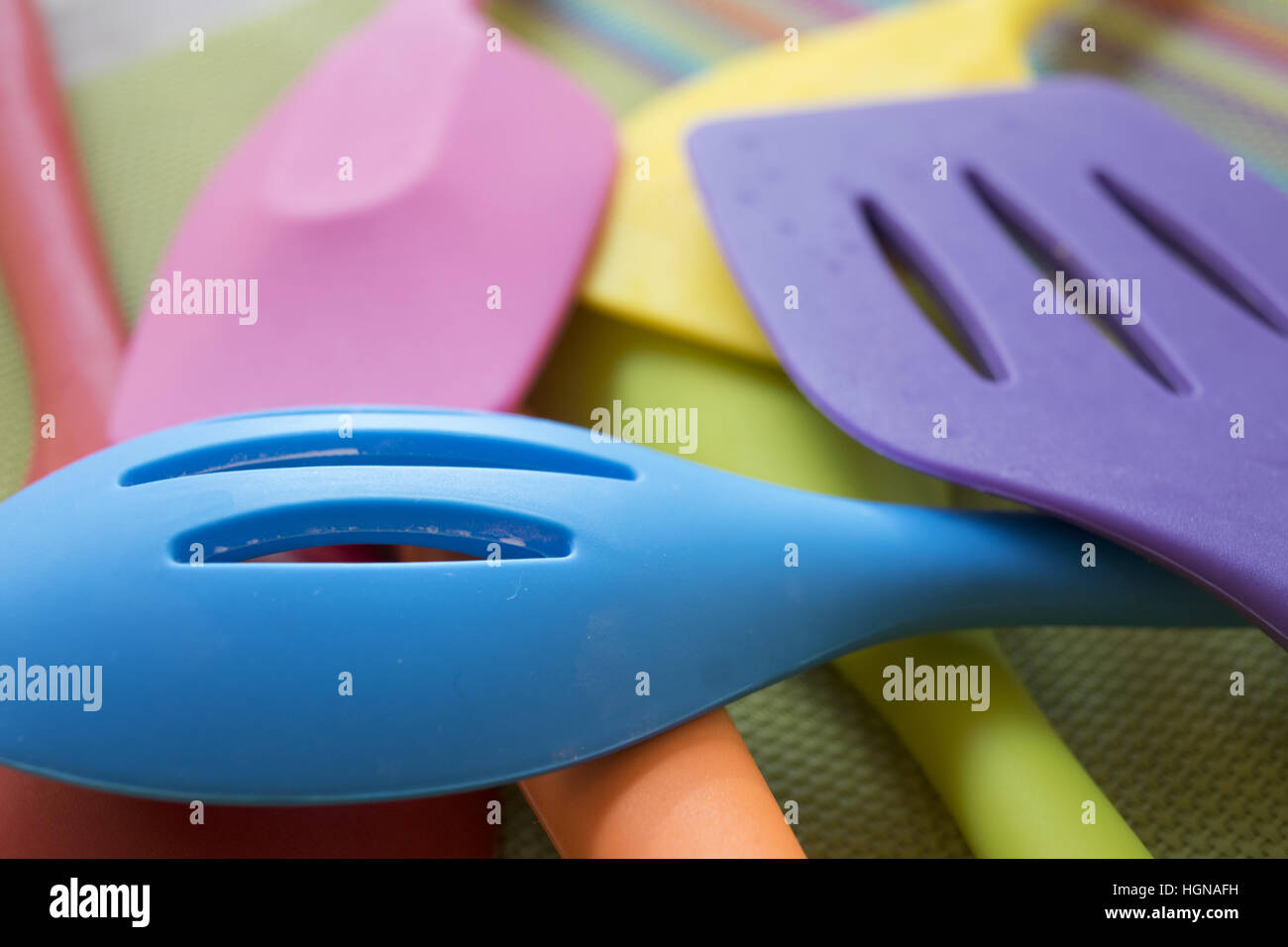 colored plastic ladles with a spoon in foreground Stock Photo - Alamy