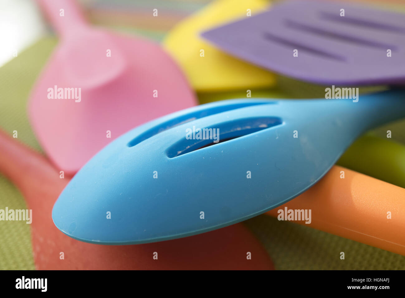 colored plastic ladles with a spoon in foreground Stock Photo - Alamy