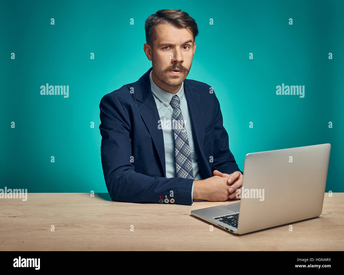 Sad Young Man Working On Laptop At Desk Stock Photo - Alamy