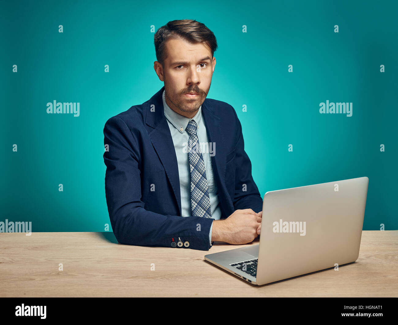 Sad Young Man Working On Laptop At Desk Stock Photo - Alamy