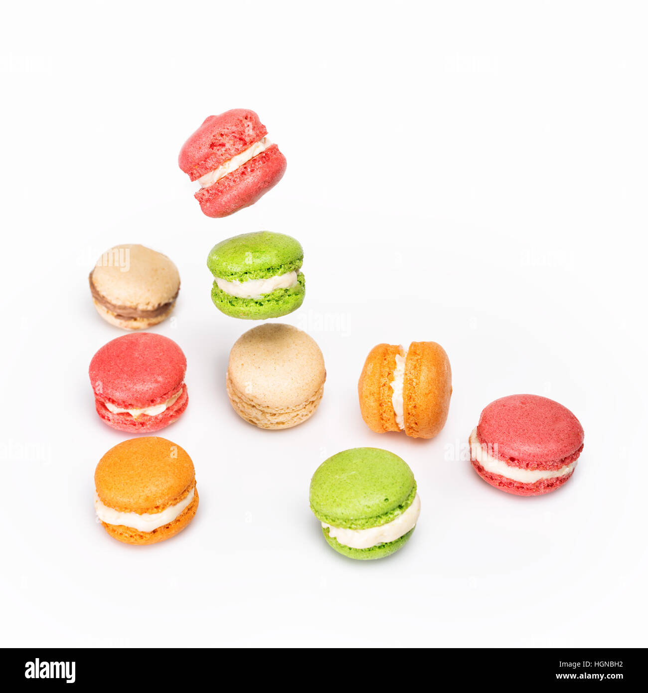 Different types of macaroons in motion falling on white background ...