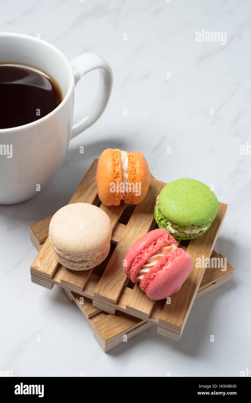 Sweet and colourful macaroons served on little wooden pallets with cup ...