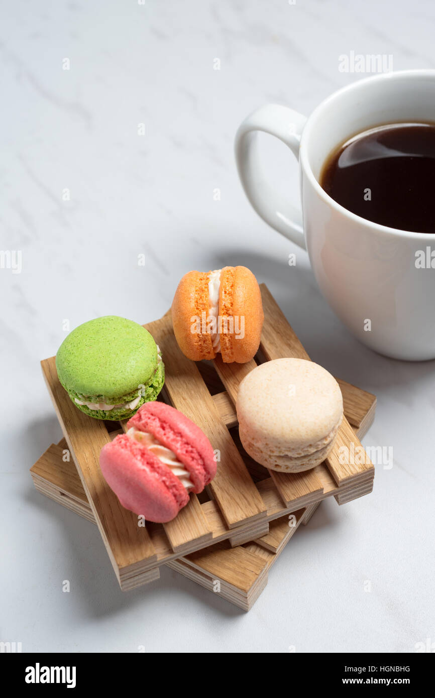 Sweet and colourful macaroons served on little wooden pallets with cup ...