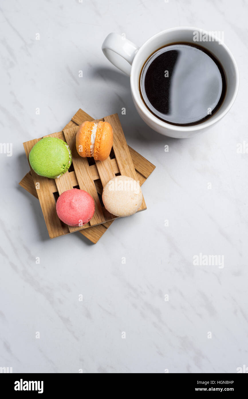 Sweet and colourful macaroons served on little wooden pallets with cup ...
