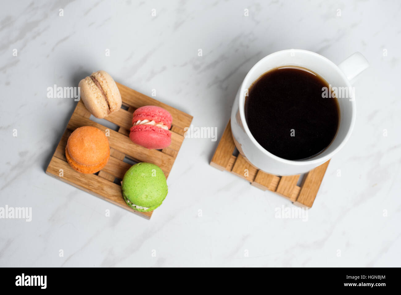Sweet and colourful macaroons served on little wooden pallets with cup ...