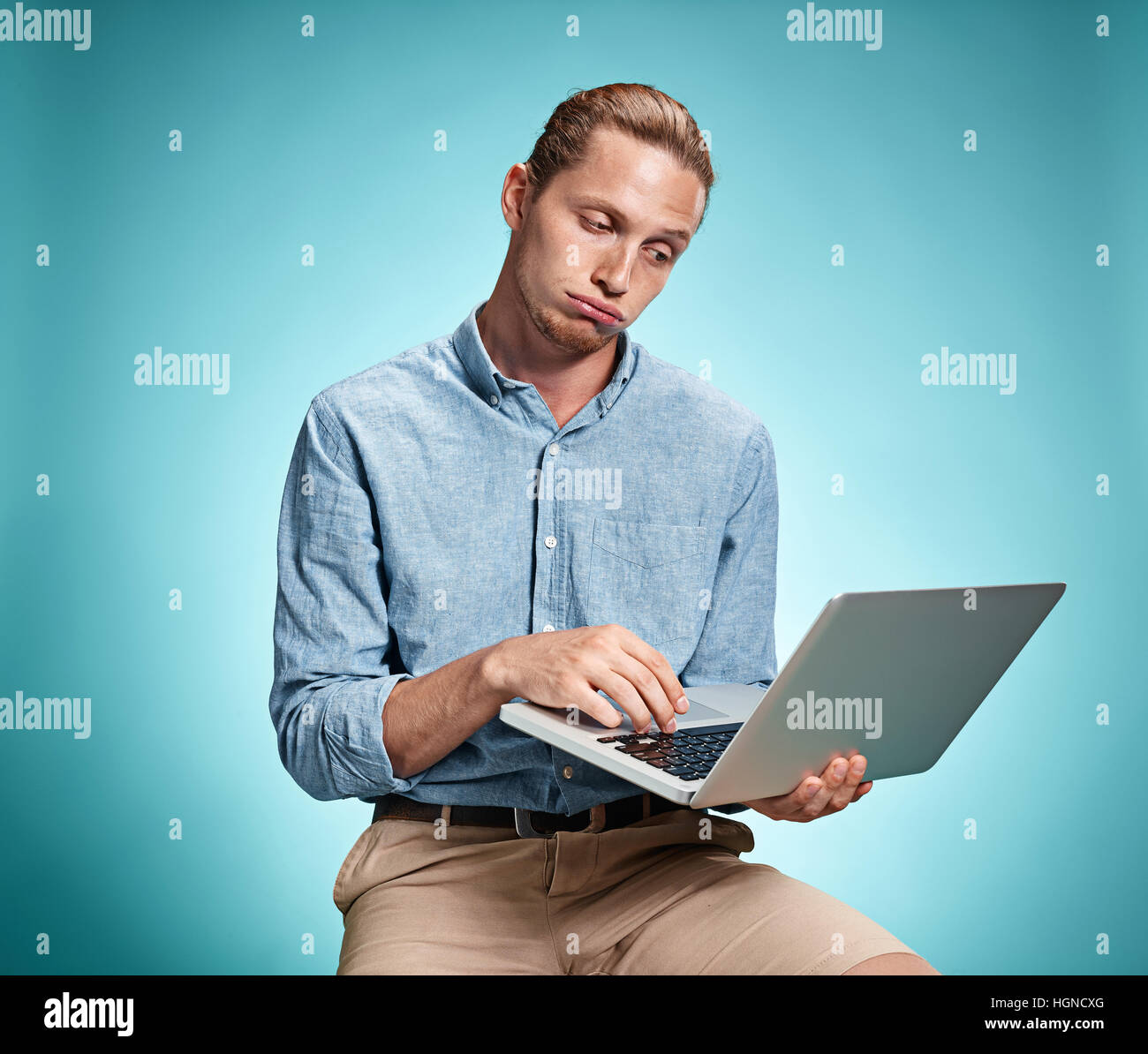 Sad Young Man Working On Laptop Stock Photo - Alamy