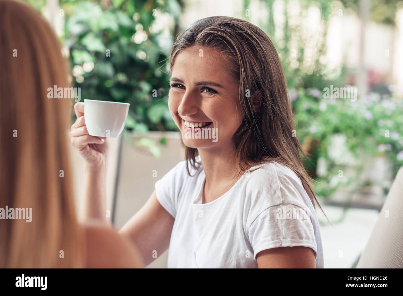 Friends chatting over coffee at a cafe Stock Photo - Alamy