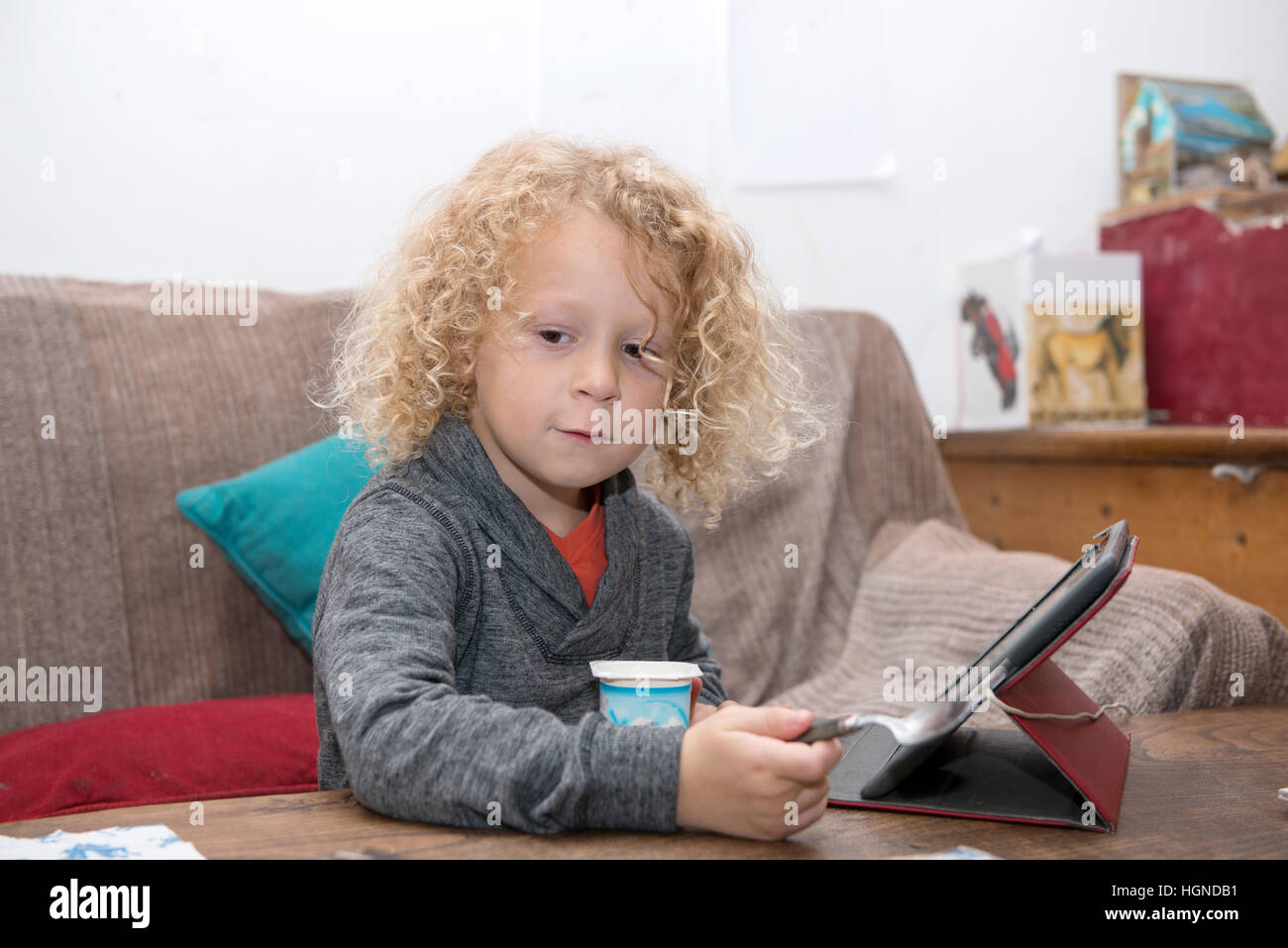 little blond boy using tablet computer at home Stock Photo - Alamy