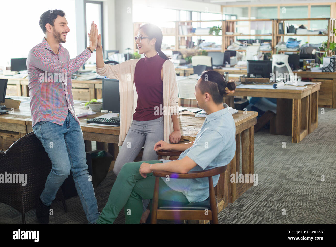 Architects high fiving in the office Stock Photo - Alamy