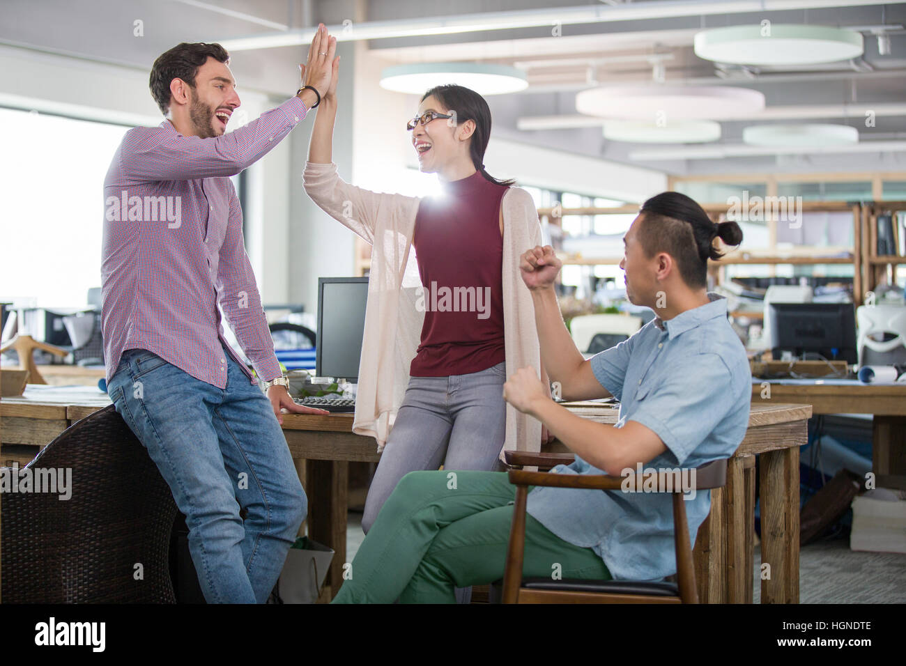 Architects high fiving in the office Stock Photo - Alamy