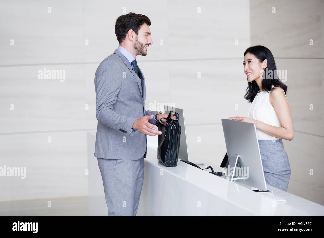 Young multi ethnic receptionist talking hi-res stock photography and ...