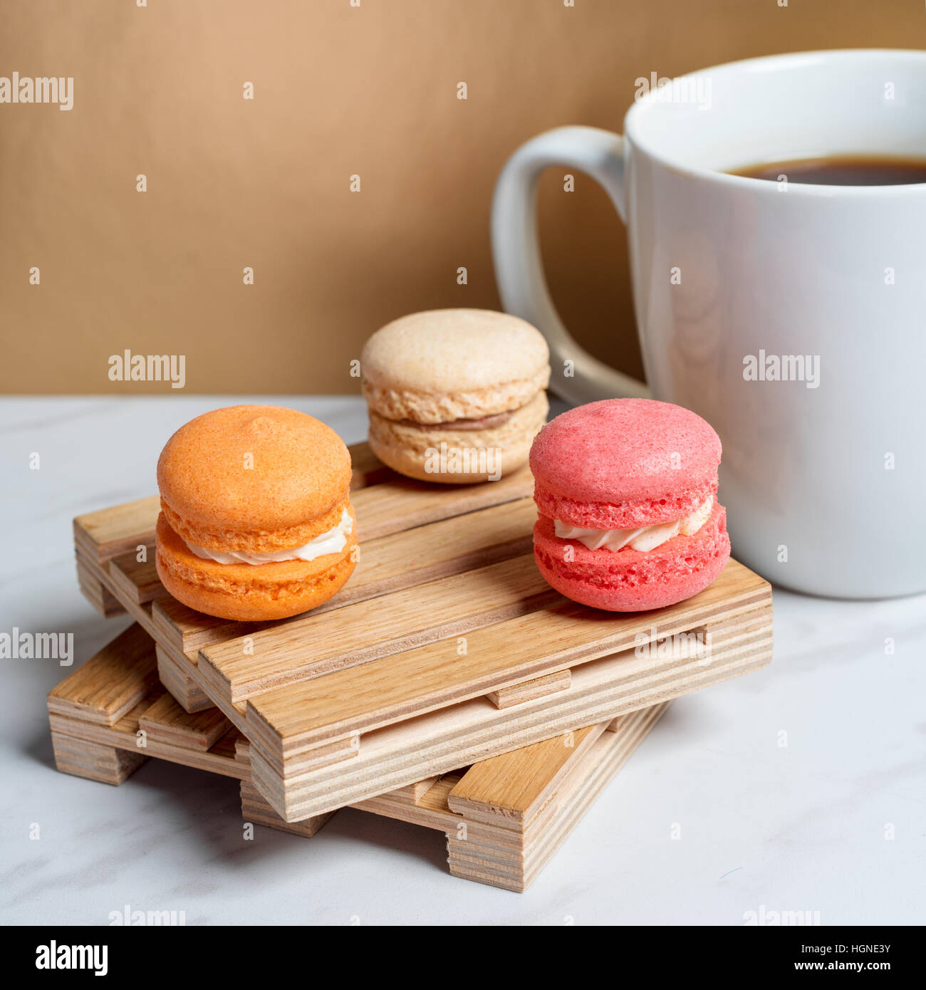 Sweet and colourful macaroons served on little wooden pallets with cup ...