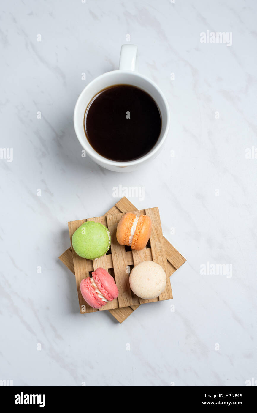 Sweet and colourful macaroons served on little wooden pallets with cup ...