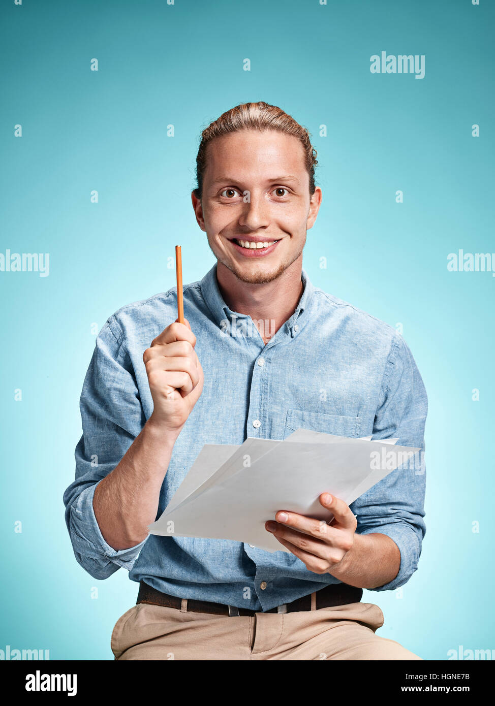 Smart smiling student with great idea holding sheets of paper Stock ...