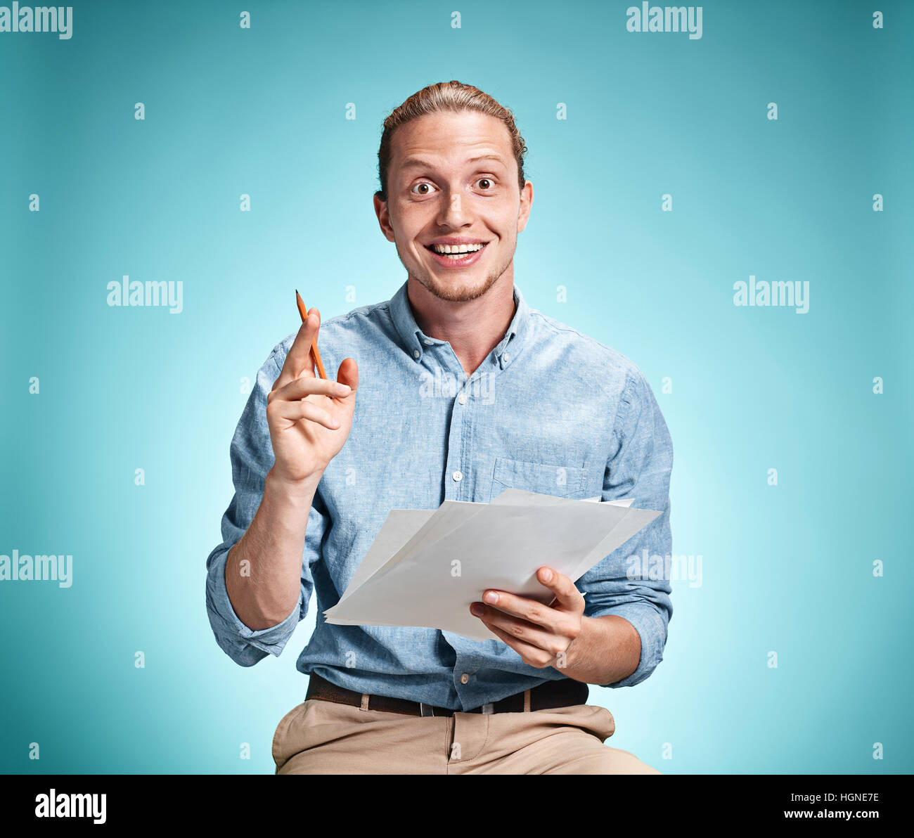 Smart smiling student with great idea holding sheets of paper Stock ...