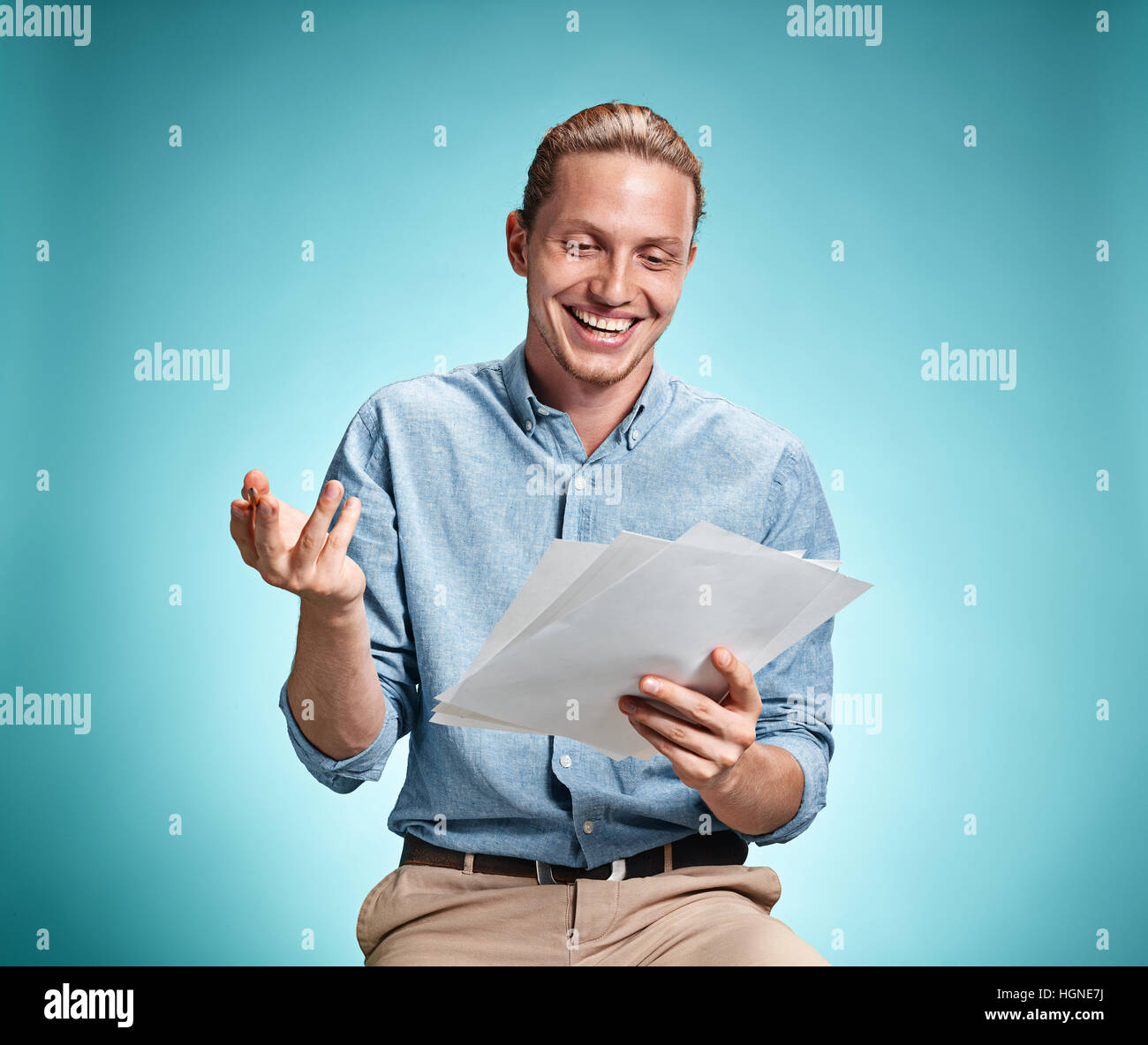 Smart smiling student with great idea holding sheets of paper Stock ...