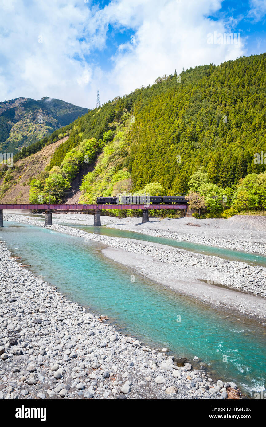 Vintage passenger train with electric locomotive at a long bridge ...